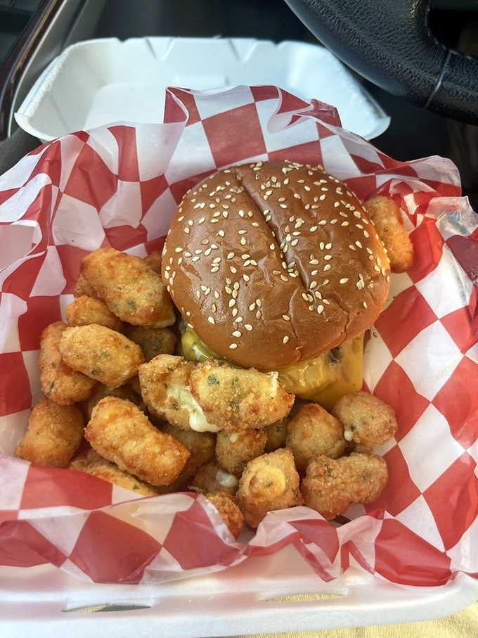 This sesame seed bun cradles a burger and cheese curds like a delicious family reunion on a plate.