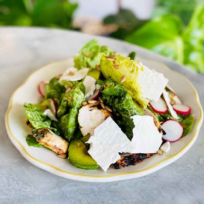 Grilled chicken nestled among fresh greens and radishes shows that French salads mean serious business.