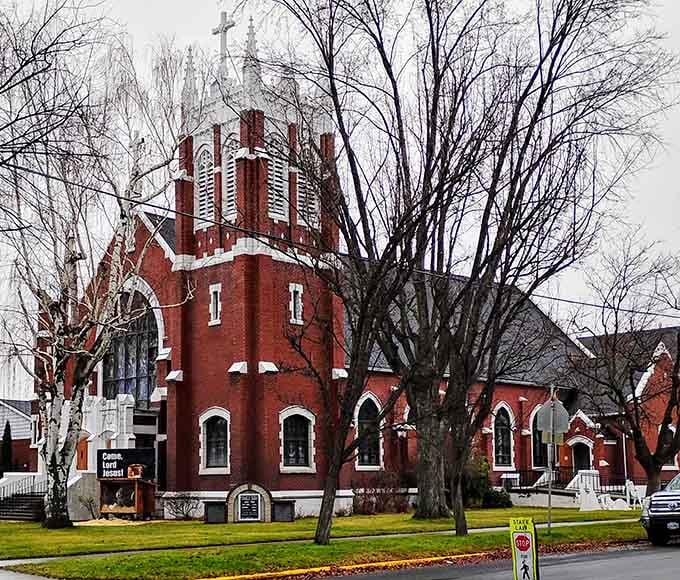Red brick church standing proud, serving a community where tithing doesn't compete with impossible housing costs for budget priority.