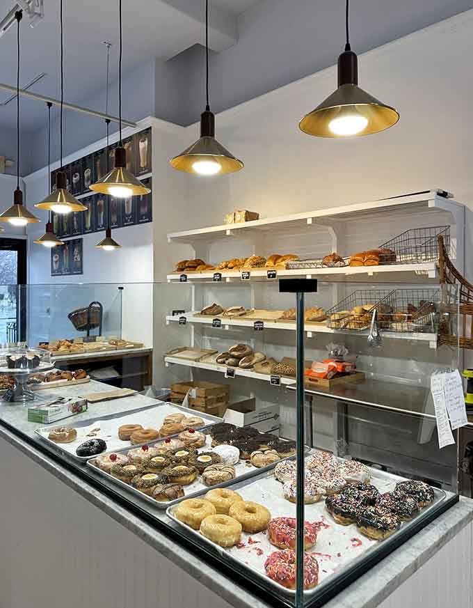 The display counter showcases pastries like edible artwork, each one practically begging to come home with you today.