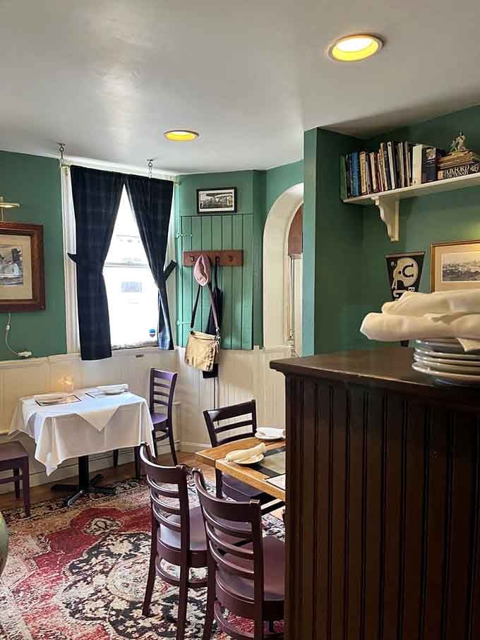 Sage-green walls and white wainscoting create a dining room that feels like stepping into a charming European bistro without the jet lag.