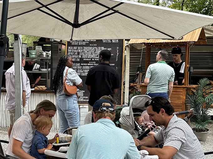 The casual vibe means families, friends, and solo diners all find their happy place under these umbrellas and trees.