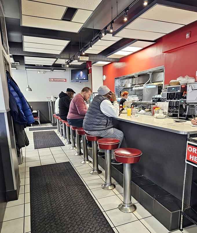 Classic diner stools lined up like soldiers, each one a front-row seat to your breakfast being made.