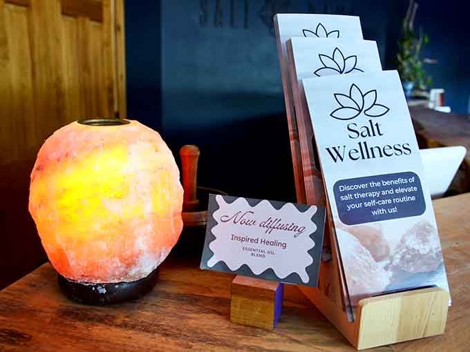 A glowing Himalayan salt lamp next to wellness brochures, inviting you to discover halotherapy's benefits for yourself today.