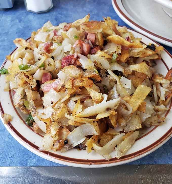 Hash browns loaded with onions and bacon bits turn a simple side into the main event worth celebrating.