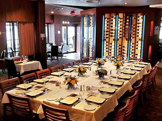 Floor-to-ceiling wine displays and warm lighting create the kind of ambiance that makes every meal feel like a special occasion.