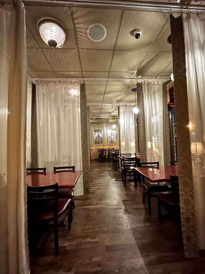 Curtained booths and warm lighting create intimate dining spaces perfect for romance, espionage, or just avoiding your neighbors.