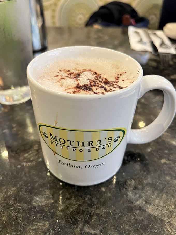 Hot chocolate with a mountain of whipped cream, served in a mug that reminds you to call your mother.