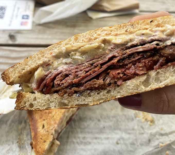 Look at that pastrami reuben cross-section: layers of meat, melted cheese, and all the classic fixings done right.