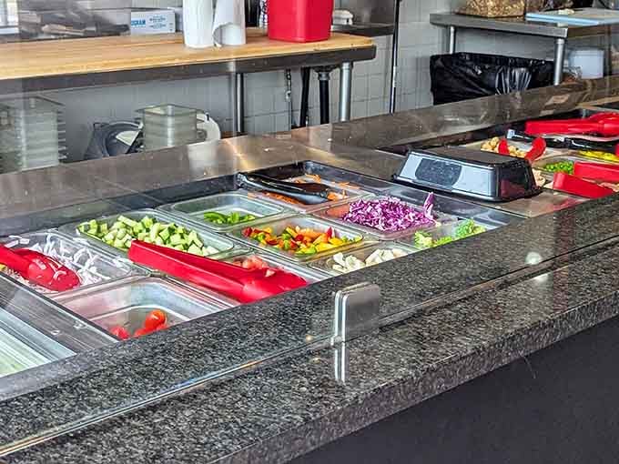 Fresh peppers, cucumbers, and tomatoes arranged like edible jewels await their transformation into your perfect custom creation.