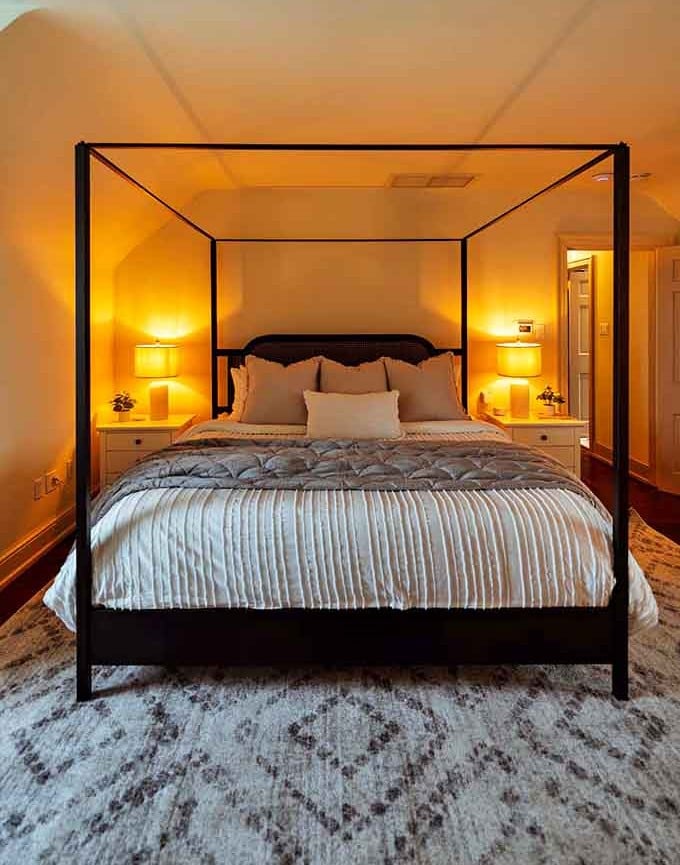 That canopy bed frame is doing more heavy lifting for the room's ambiance than most furniture ever dreams of.