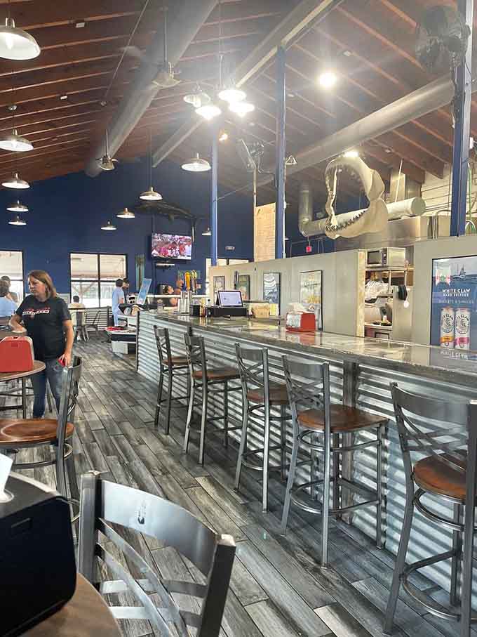 The bar stretches invitingly across the space, perfect for solo diners or anyone wanting front-row seats to dinner theater.