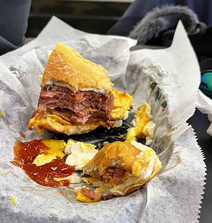 The breakfast sandwich in its natural habitat, partially devoured because nobody has that kind of willpower.