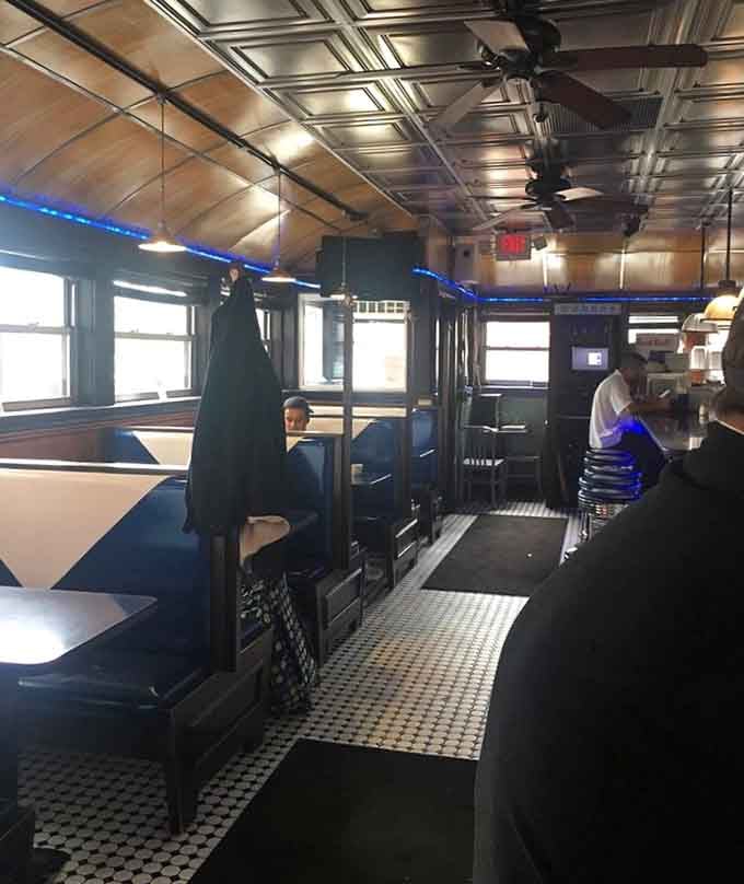 Blue vinyl booths offering cozy refuge where you can settle in and take your sweet time with that stack.