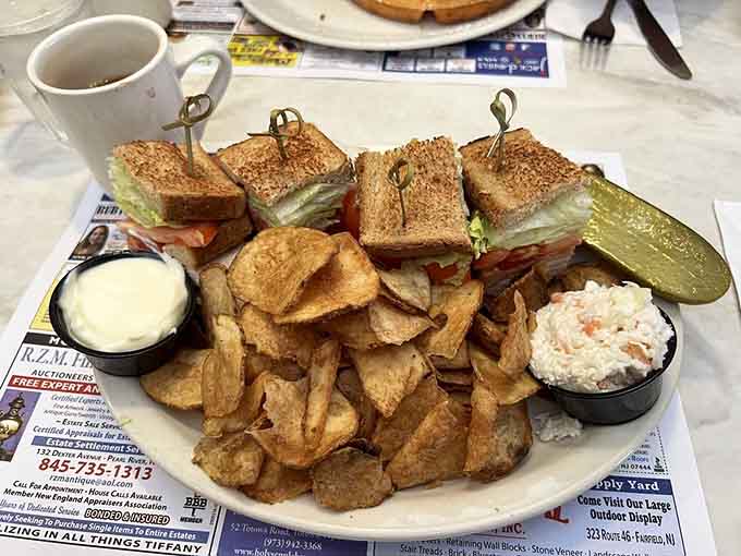 A proper triple-decker club sandwich with chips and coleslaw is the kind of lunch that makes you remember why sandwiches were invented.