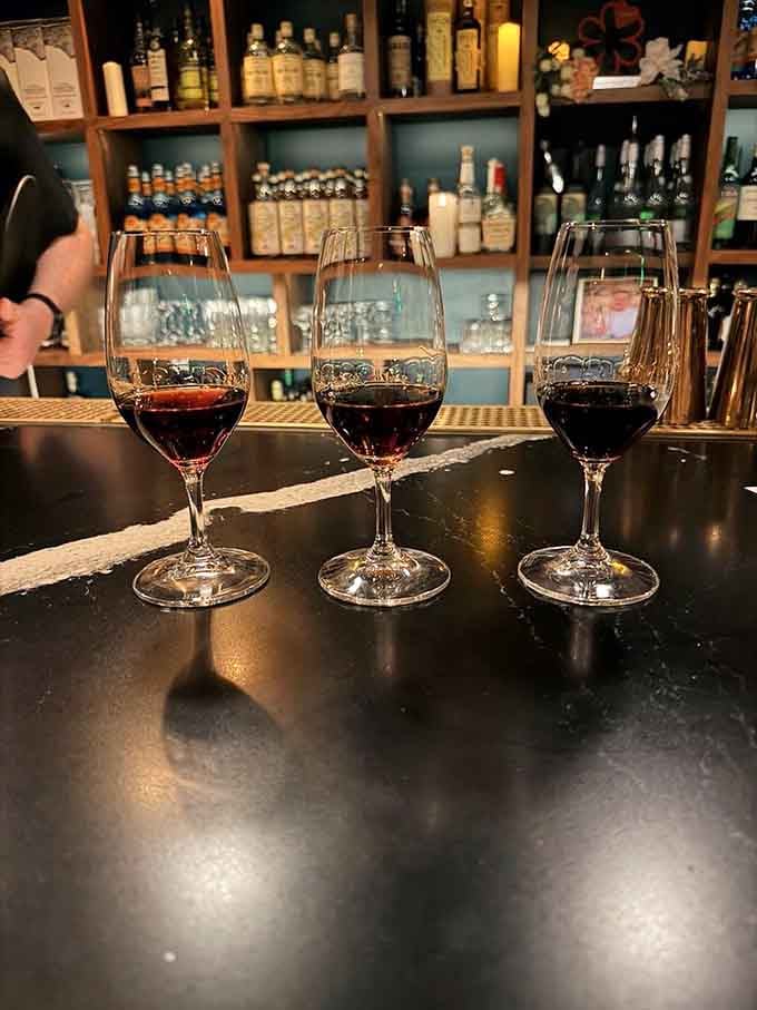 Three wine glasses lined up for a proper tasting flight, because unlimited food deserves equally thoughtful beverage pairings.