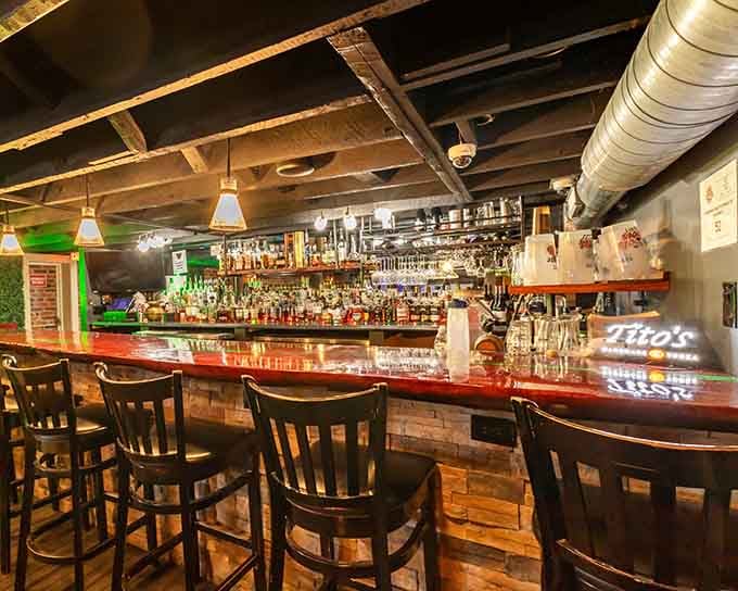 The bar stretches invitingly with bottles lined up like soldiers, ready to serve whatever helps you unwind after a long day.