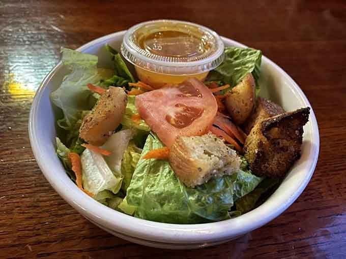 Fresh garden salad with golden croutons and ripe tomatoes proves even the lighter options here get serious attention.