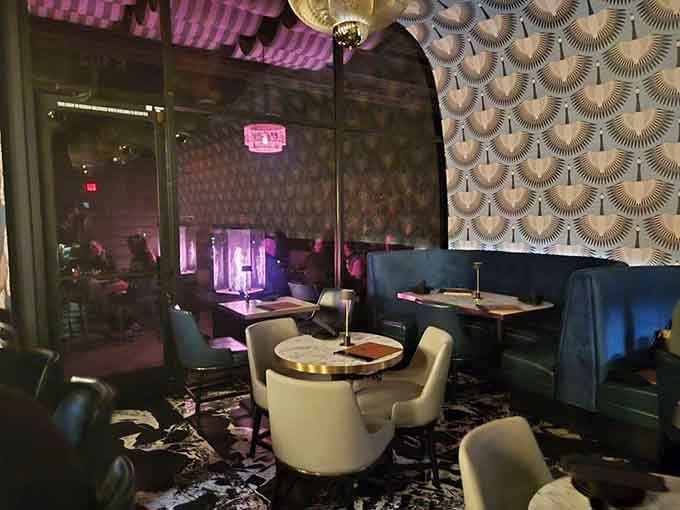 The moody lighting and plush seating create intimate spaces where time slows down and conversations deepen naturally.