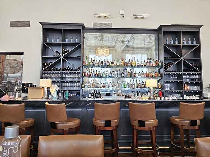 A well-stocked bar with leather stools invites you to settle in for a proper cocktail before your meal arrives.