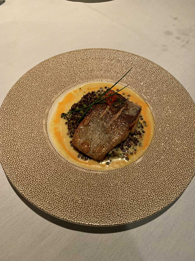 Pan-seared kanpachi on a textured gold plate, because sometimes your fish deserves to dine as fancy as you do.