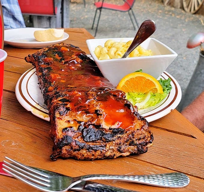 A full rack of baby back ribs glazed with homemade BBQ sauce that practically falls off the bone before you touch it.
