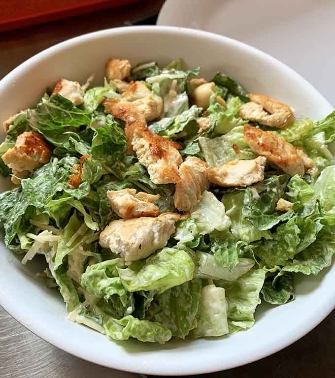 Fresh Caesar salad with grilled chicken, proving this former bank now deals in greens as well as breakfast dreams.