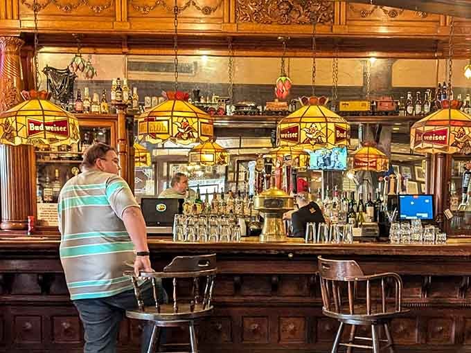 The ornate bar with Budweiser lamps overhead channels classic saloon vibes with authentic style and flair.