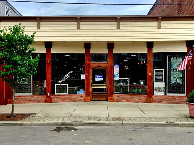 Village Salvage's red columns frame a storefront that promises architectural treasures and salvaged dreams waiting inside.
