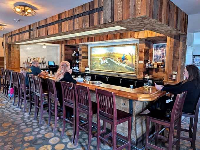 The bar area combines rustic wood with Western artwork, creating the perfect spot for pre-dinner cocktails.