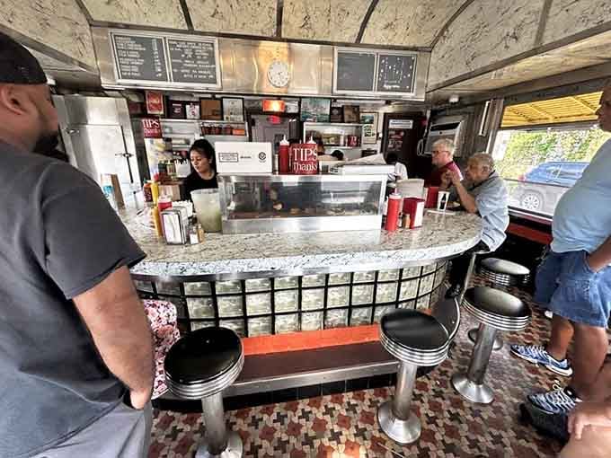 The horseshoe counter puts you front row for the griddle show, where every burger gets its moment to shine.