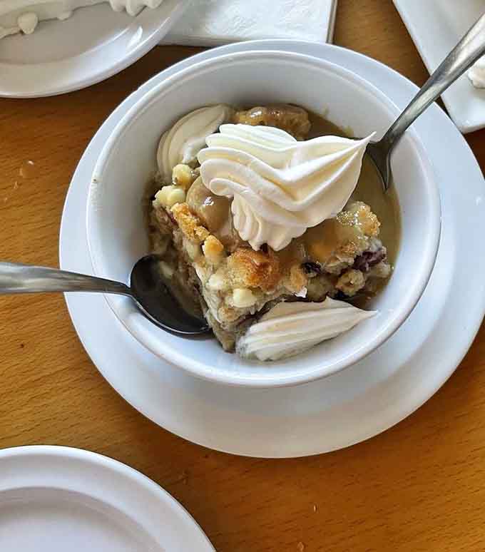 Bread pudding topped with whipped cream and caramel: the sweet ending your seafood feast absolutely deserves and needs.