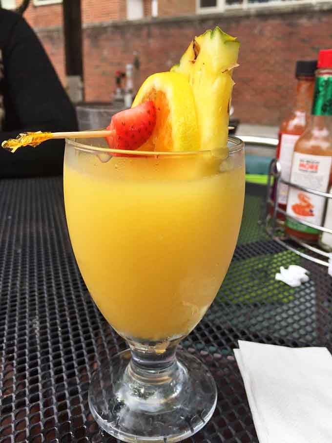 A mimosa garnished with fresh fruit, because brunch without bubbles is just a sad breakfast meeting.