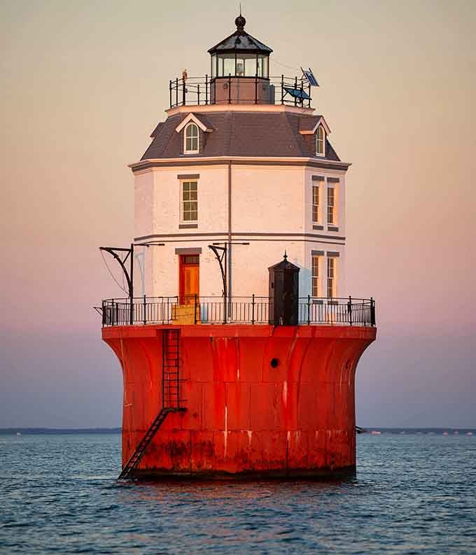 The orange door glowing at sunset makes this lighthouse look like it's welcoming sailors home for dinner tonight.