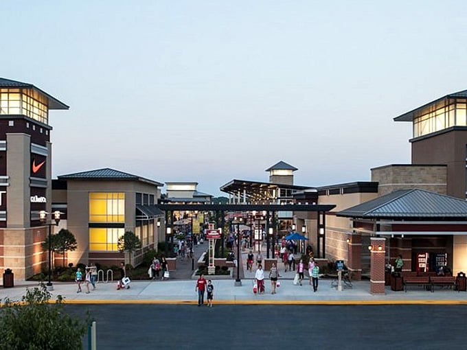 This outdoor shopping center glows at twilight, inviting evening strollers to browse under those welcoming lights.