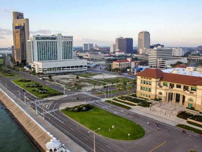 The seawall curves gracefully along the coast where green grass meets blue water, offering perfect spots for watching boats and breathing in that salty air.