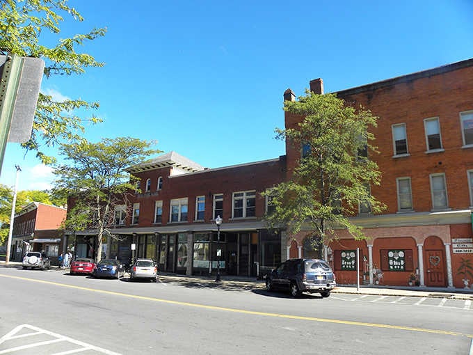 Sunny skies illuminate brick storefronts that have watched generations of neighbors greet each other by name daily.