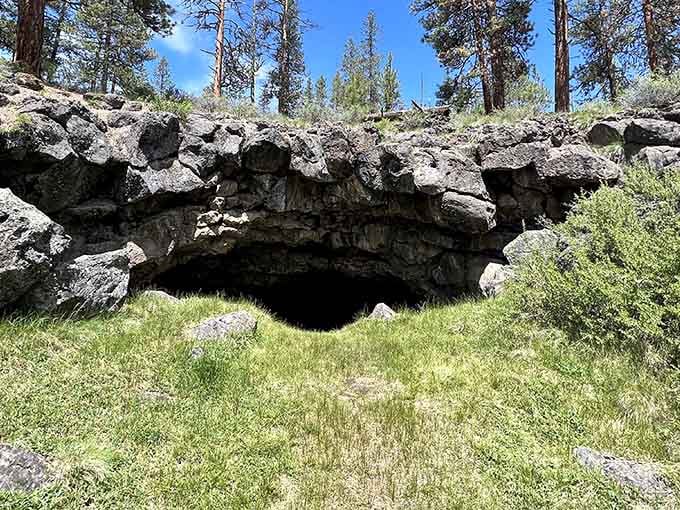Green grass surrounds this dark opening in the earth, inviting you to explore the volcanic underworld below.