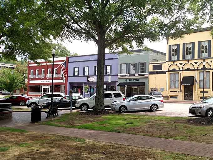 The town square's colorful buildings and shady trees create a postcard-perfect scene that's actually real life.