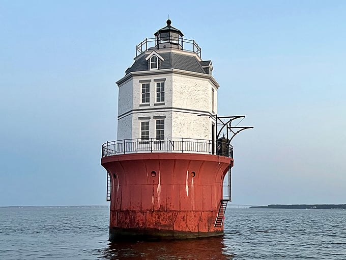 That weathered red base tells stories of storms survived while the white top reaches optimistically toward calmer skies.