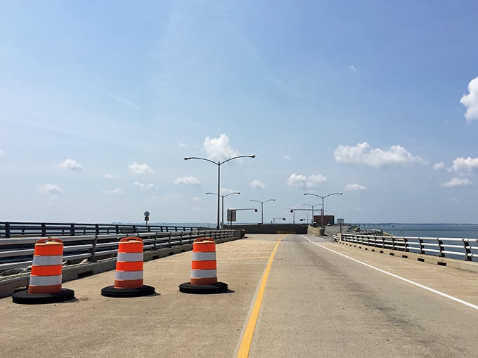 Orange construction barrels stand guard on this engineering marvel, reminding us that even wonders need occasional maintenance work.