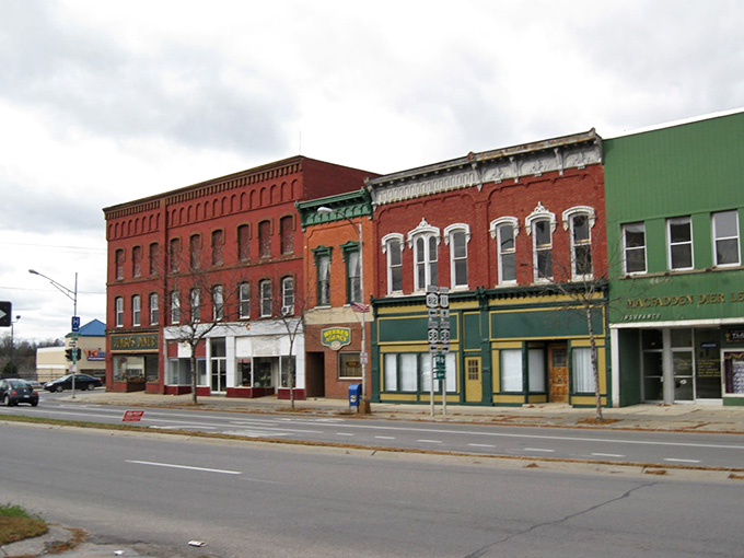Colorful storefronts in red, cream, and green create a cheerful streetscape that refuses to fade into bland uniformity or corporate sameness.