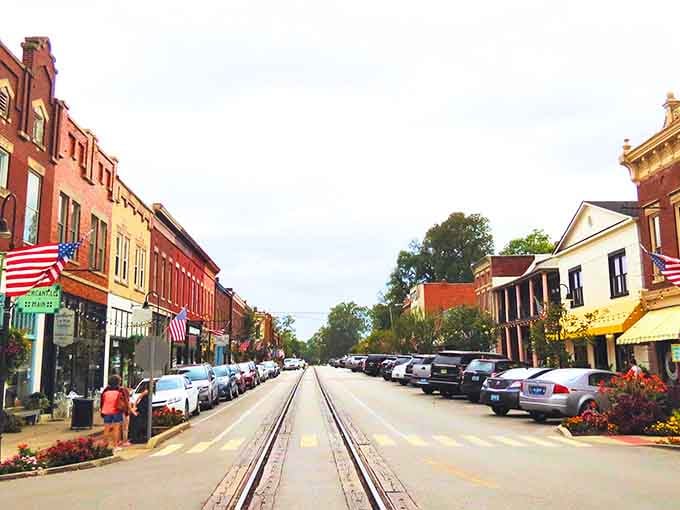 Golden light bathes the storefronts while Old Glory waves proudly, creating a scene Norman Rockwell would have loved painting.