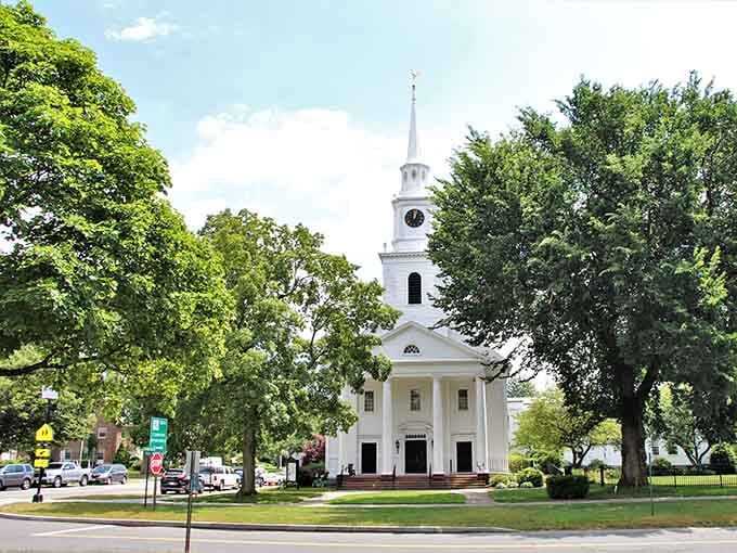 A pristine white church stands proudly among ancient trees, looking exactly like the New England you've always pictured in your mind.