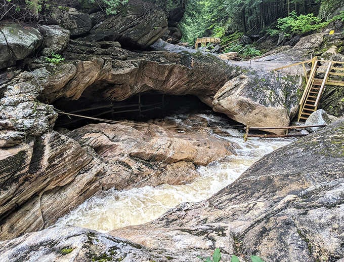 Water rushes over sculpted rock as wooden stairs guide visitors safely through this geological masterpiece of marble and time.