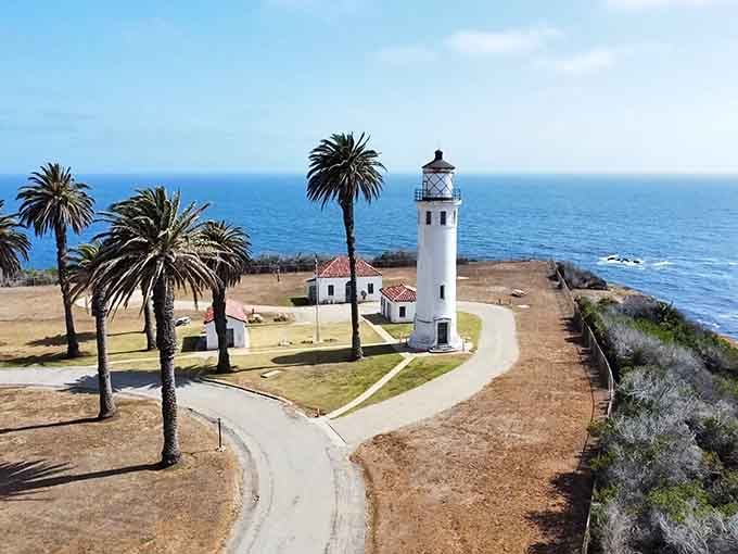 The winding path through swaying palms leads to this pristine white tower like a scene from an old Hollywood movie.