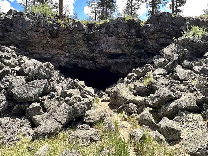 Jagged lava rocks frame the entrance to this cave, where ice persists even during summer's heat.