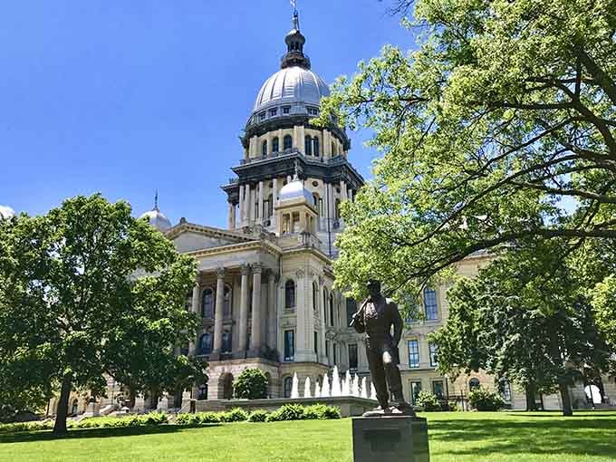 The State Capitol dome rises through summer trees, majestic proof that living near history doesn't require wealth.
