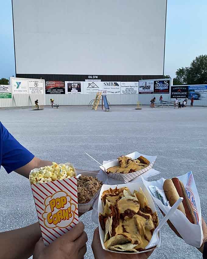Popcorn, nachos, hot dogs, and all the guilty pleasures that make movie nights perfect spread out before the giant screen.
