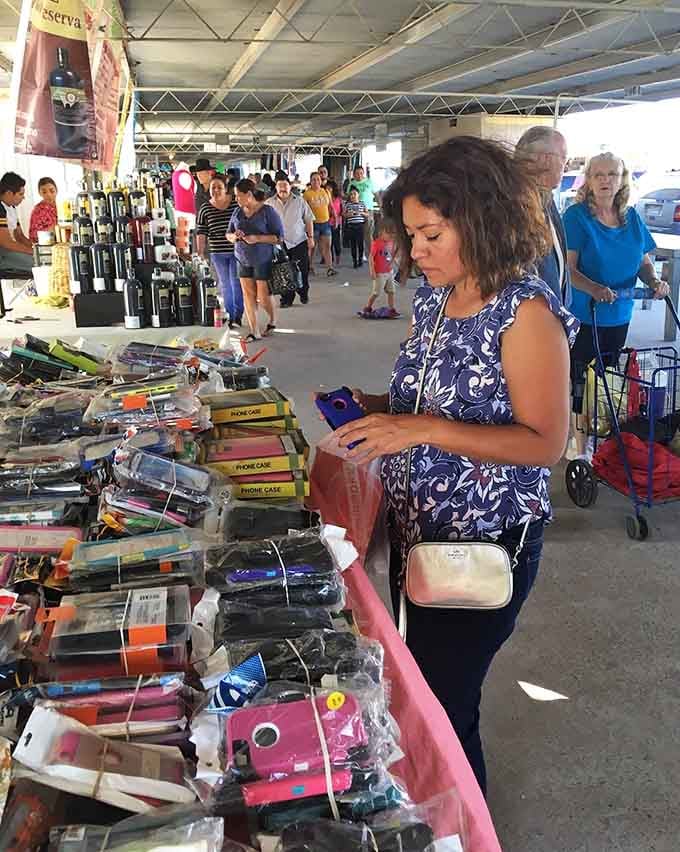 Shoppers browse phone cases with the focused intensity of archaeologists discovering ancient treasures in modern packaging.